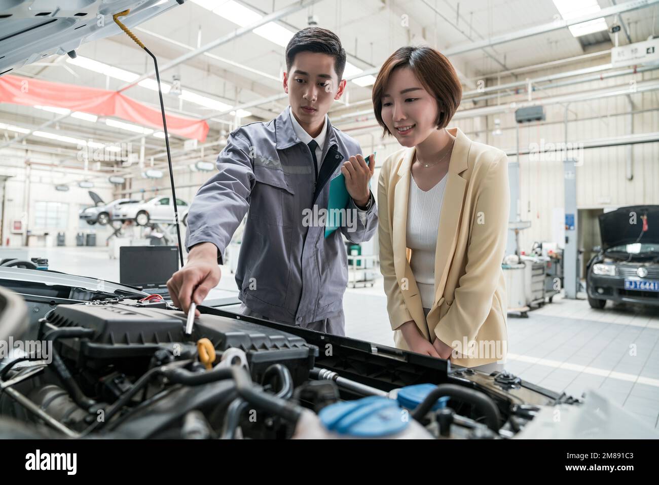 Repair shop mechanics of personnel with the customer Stock Photo - Alamy