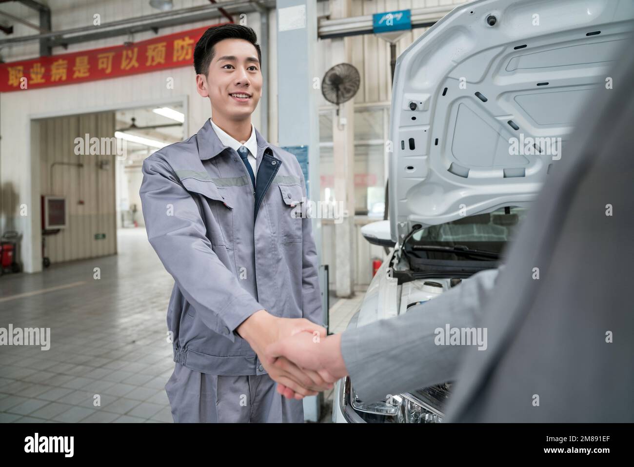 Repair shop mechanics of personnel with the customer Stock Photo - Alamy