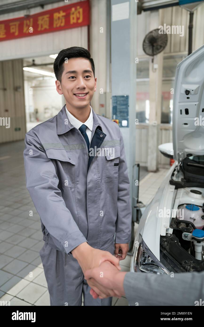Repair shop mechanics of personnel with the customer Stock Photo - Alamy