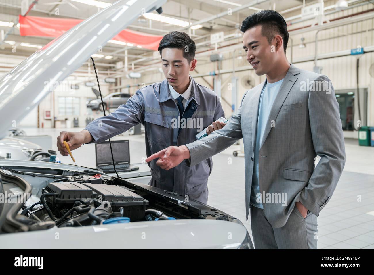 Repair shop mechanics of personnel with the customer Stock Photo - Alamy