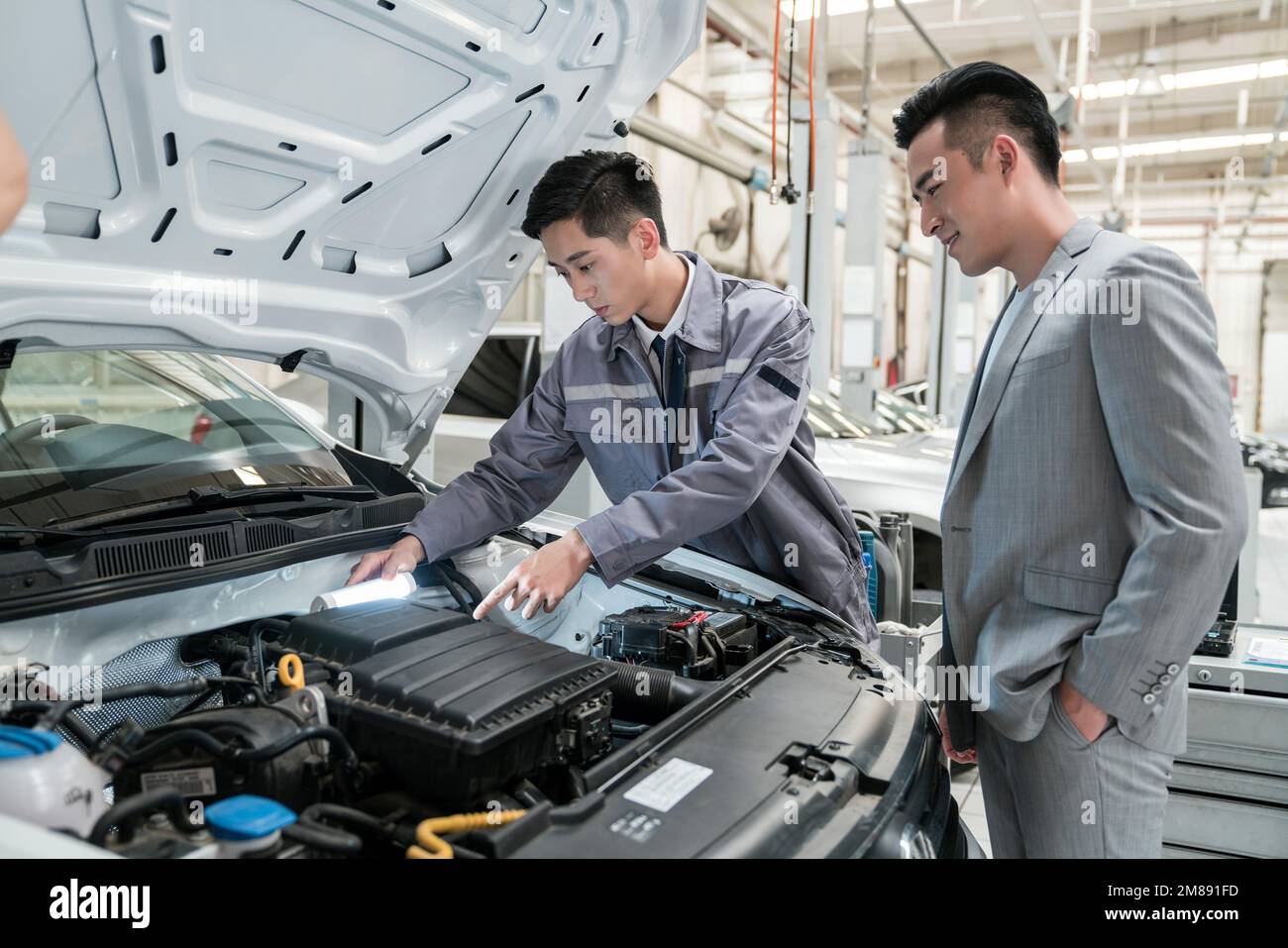 Repair shop mechanics of personnel with the customer Stock Photo - Alamy