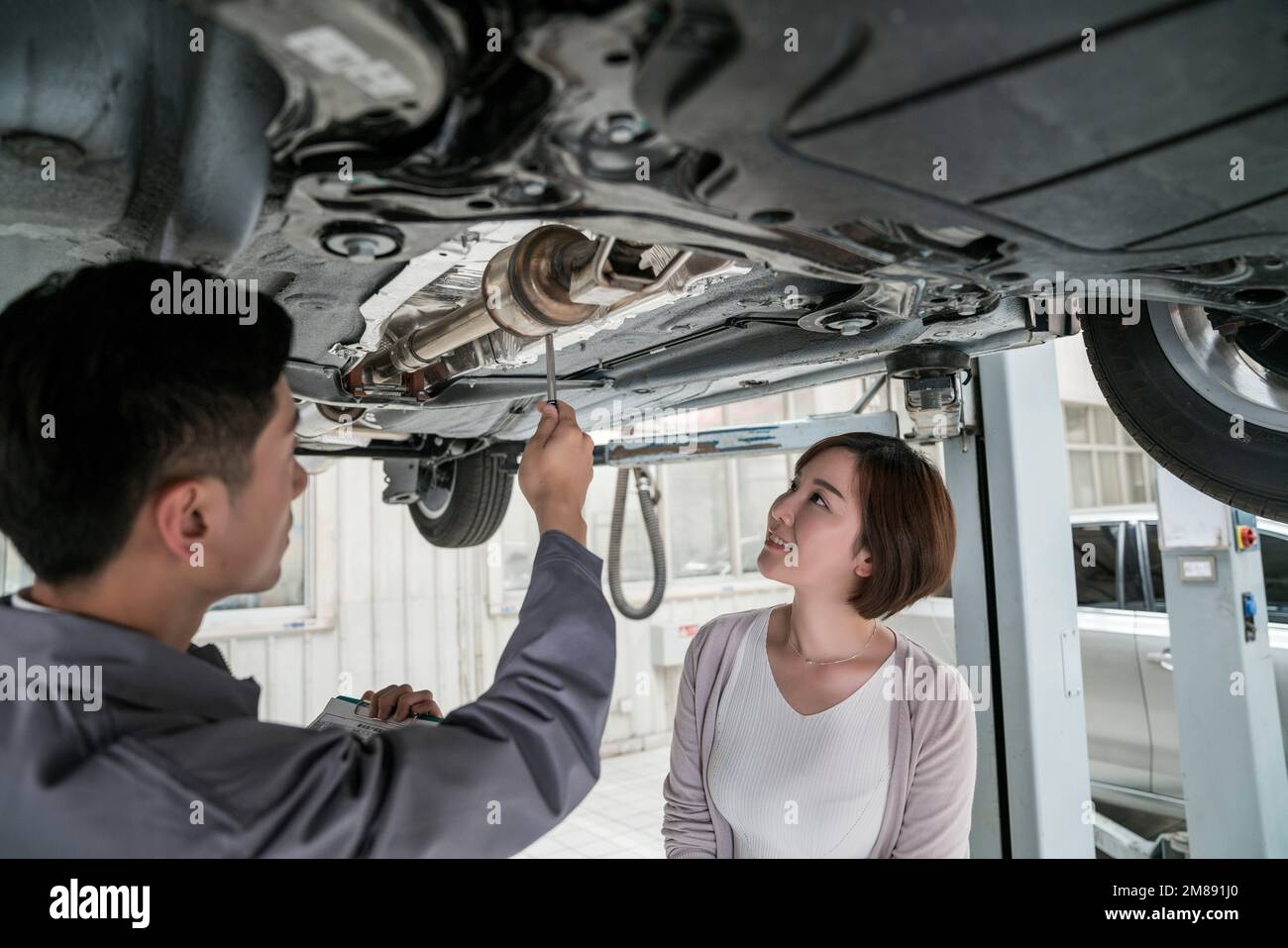 Repair shop mechanics of personnel with the customer Stock Photo - Alamy