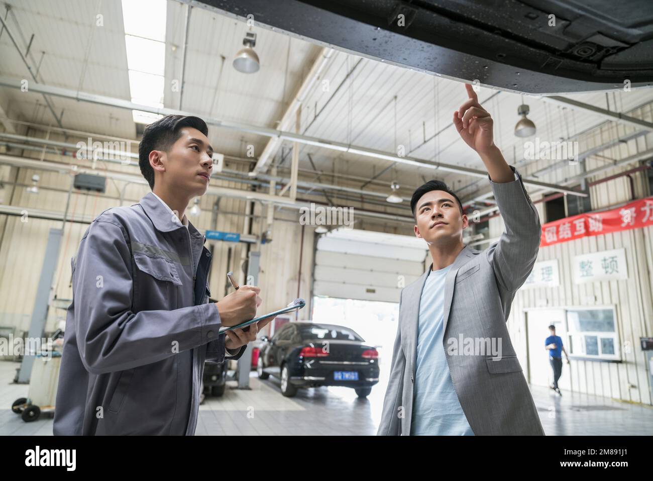 Repair shop mechanics of personnel with the customer Stock Photo - Alamy