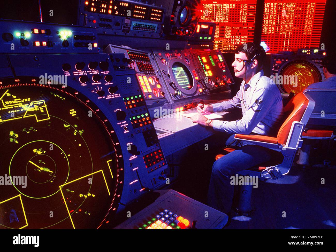 Crewmen monitor air traffic control radar consoles in the Combat ...