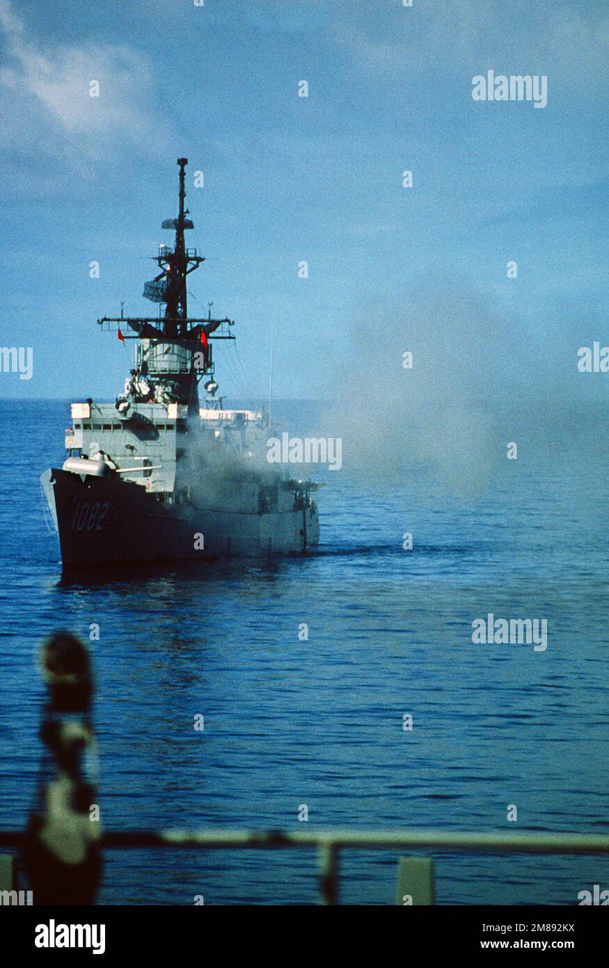 A port bow view of the frigate USS ELMER MONTGOMERY (FF-1082) firing ...