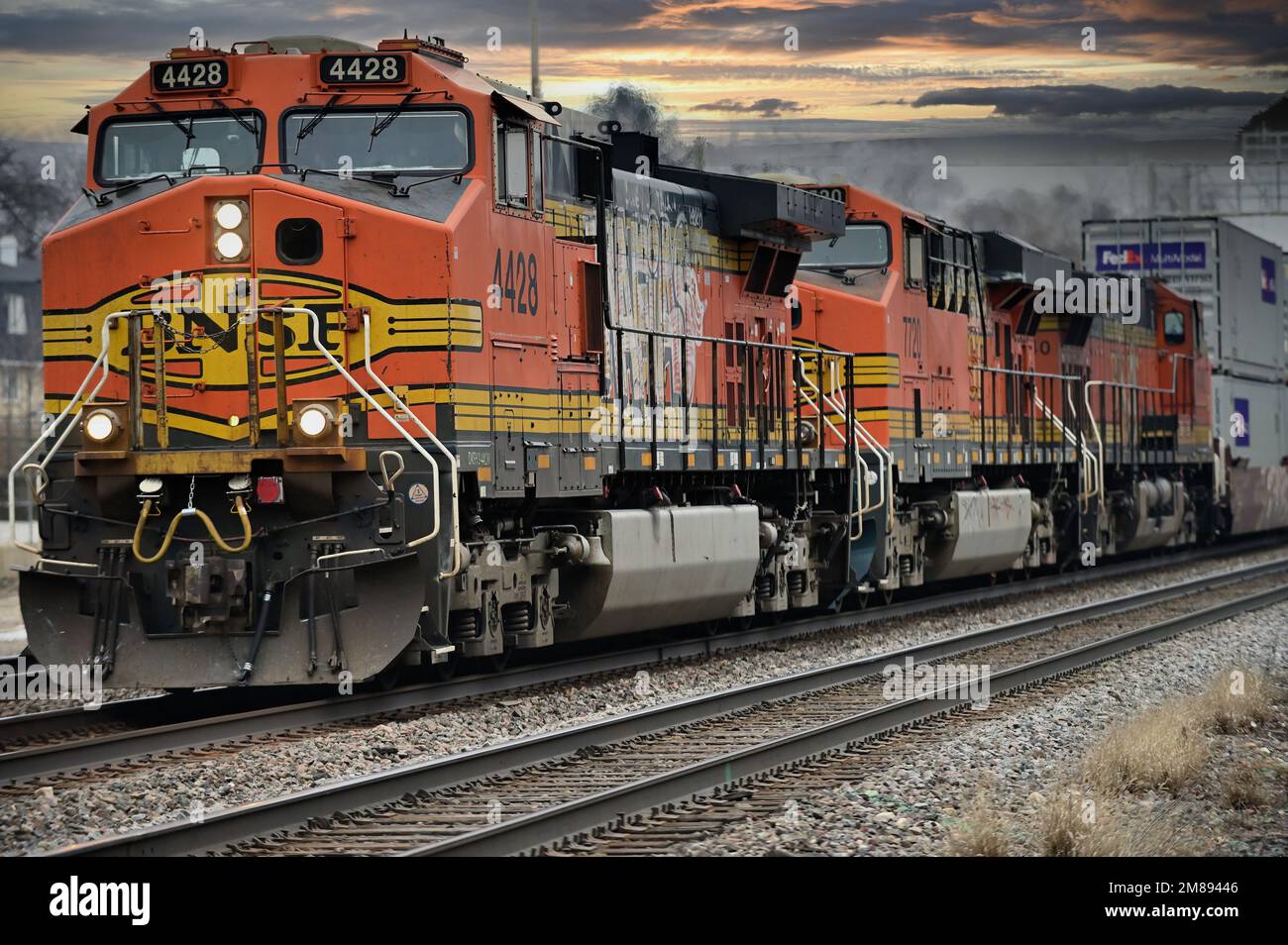 Naperville, Illinois, USA. Three Burlington Northern Santa Fe locomotives lead a freight train ...