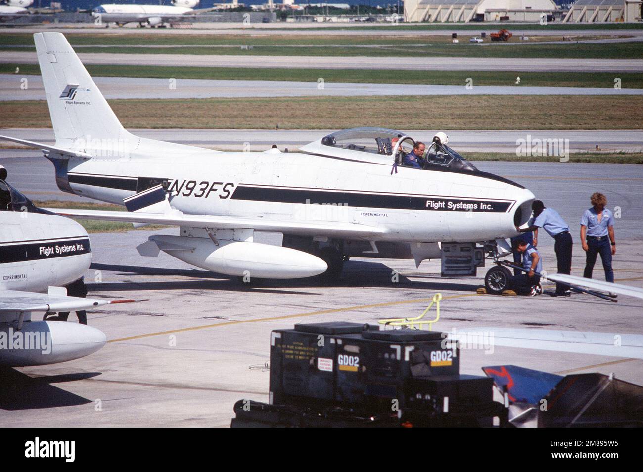 Ground crewmen inspect an F-86 aircraft as it is prepared for a mission ...