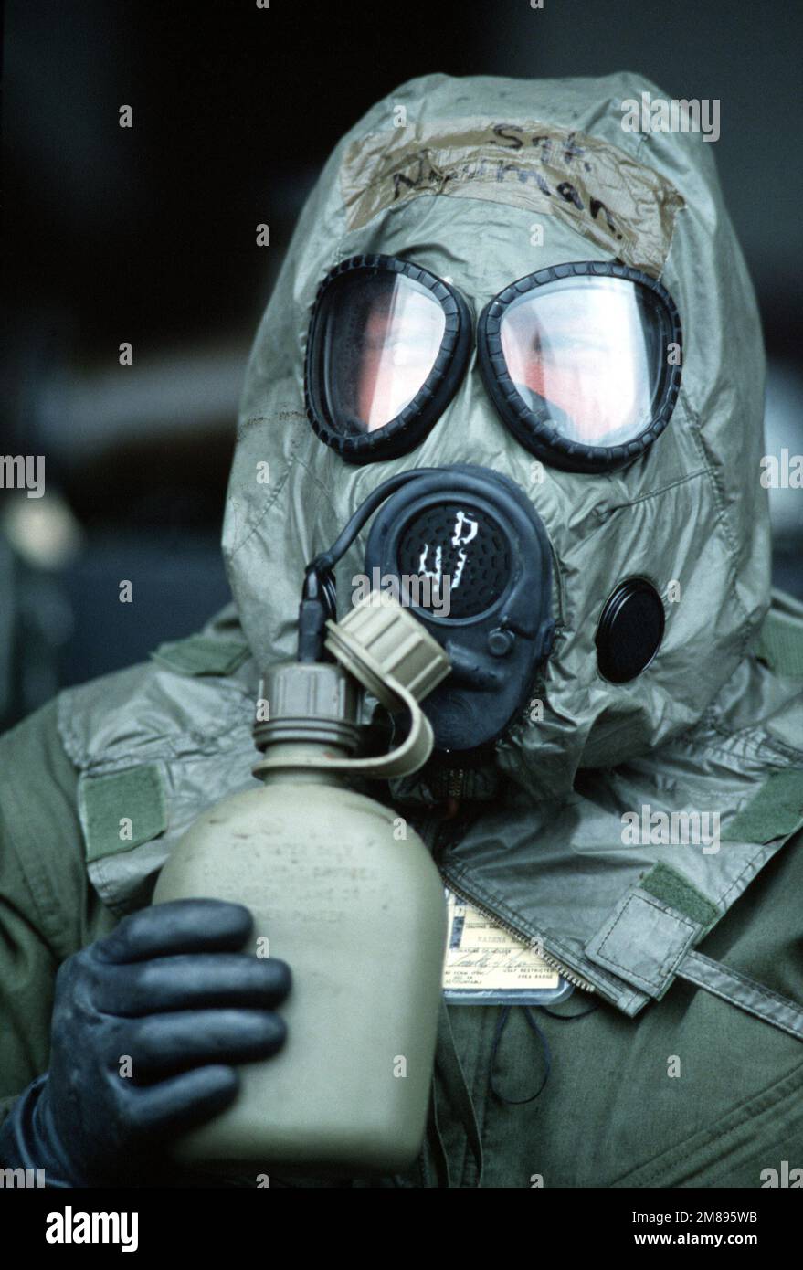A participant in a nuclear-biological-chemical warfare drill drinks ...
