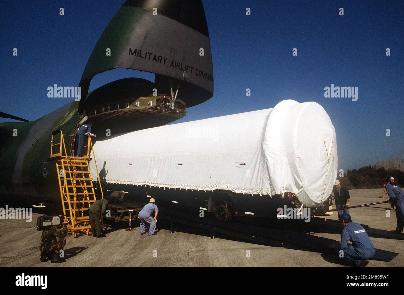 The first stage of a Titan IV launch vehicle is offloaded from a C-5B ...