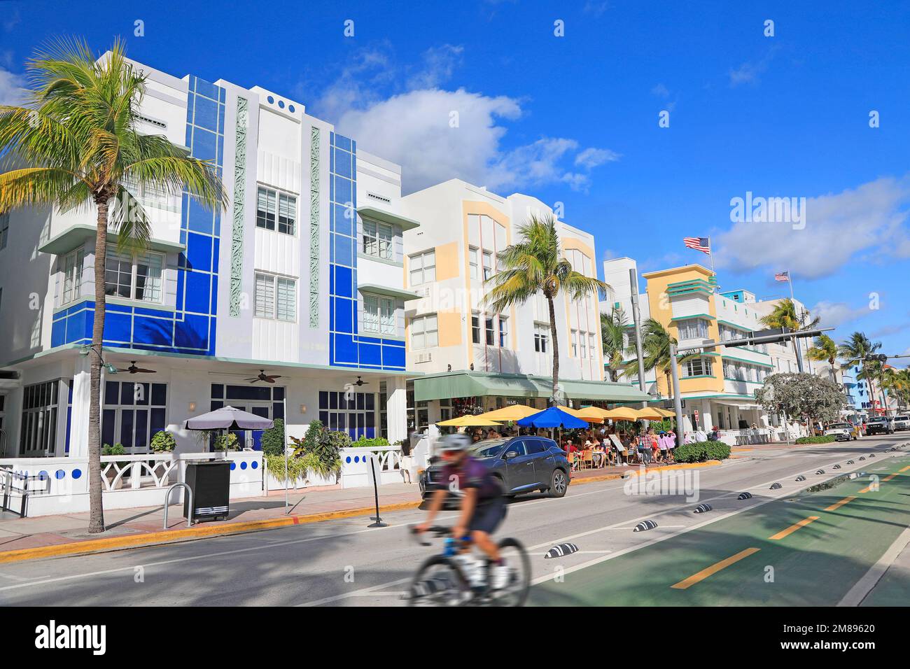 Colorful art deco hotels and cyclist on Ocean Drive in Miami Beach ...
