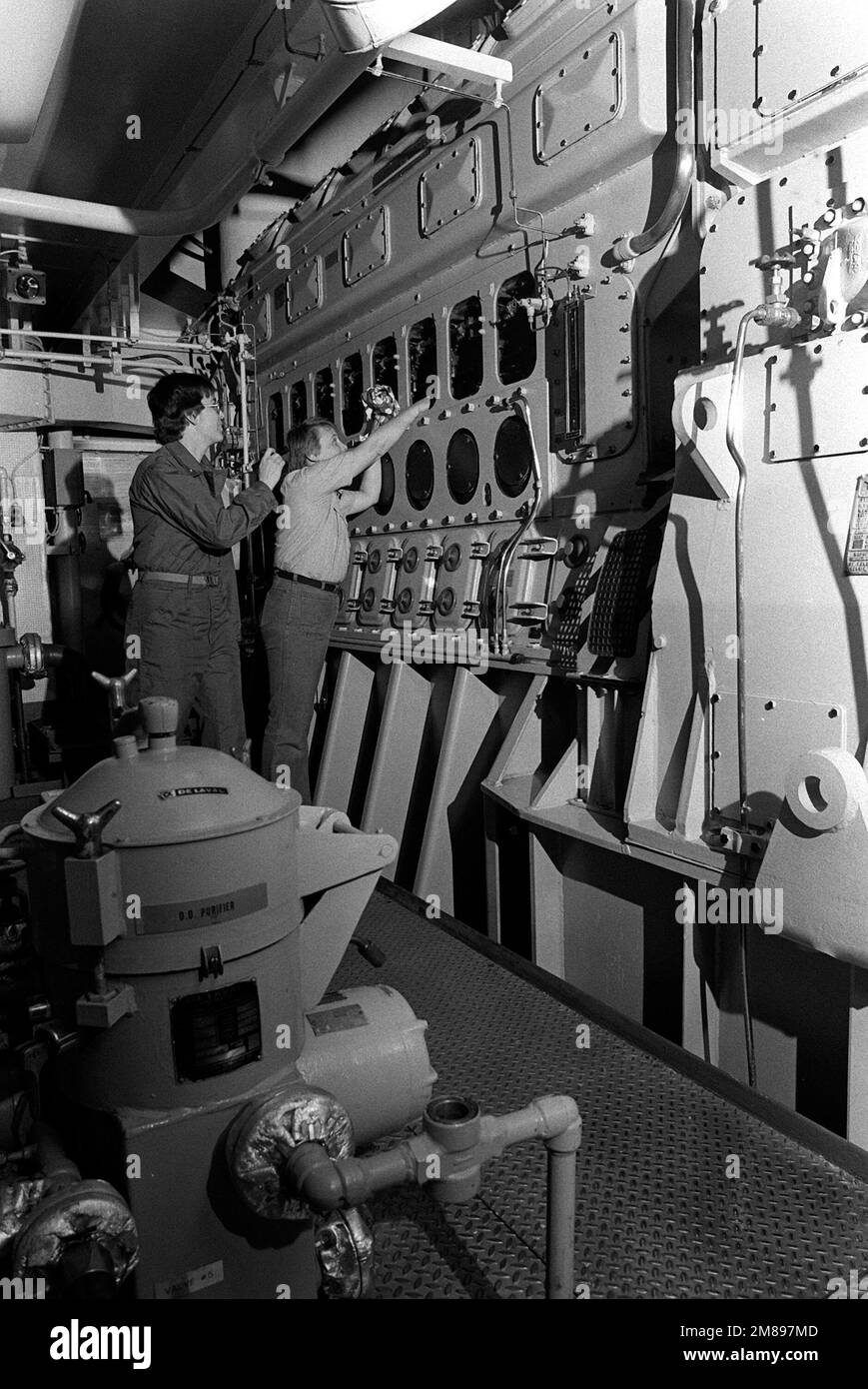 Female sailors work on a steam turbine in the engine room of the ...