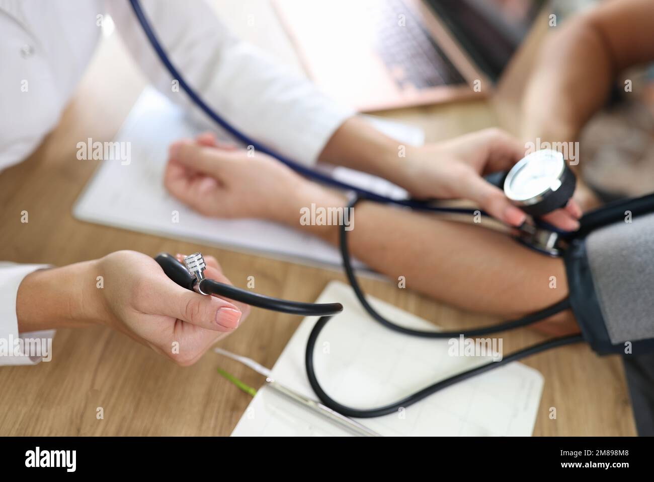 Close up of doctor using sphygmomanometer with stethoscope checks blood ...