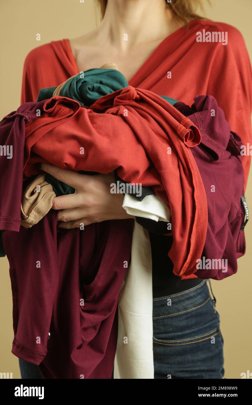 Woman holding huge pile of clothes, concept of sale, fashion ...