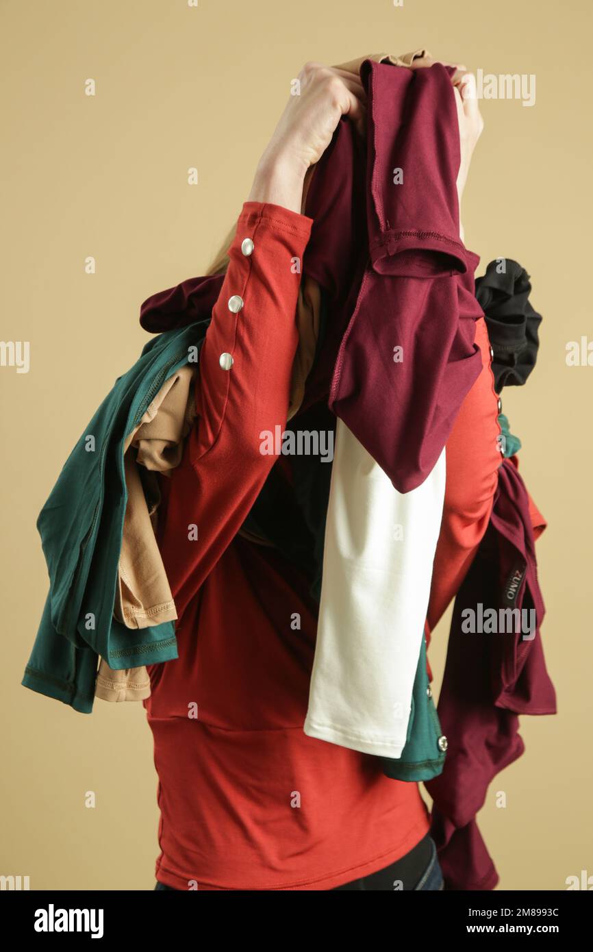 Woman holding huge pile of clothes, concept of sale, fashion ...