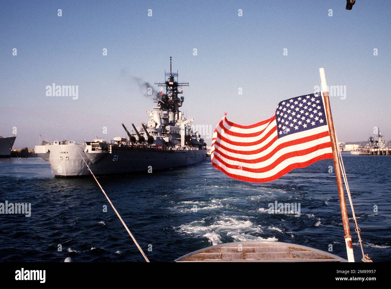 A tug boat pulls the battleship USS IOWA (BB-61) away from Pier No. 1 ...