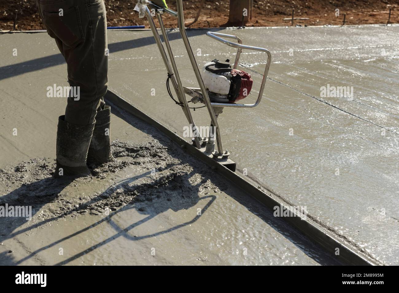 In construction new driveway machine is used to align fresh concrete ...