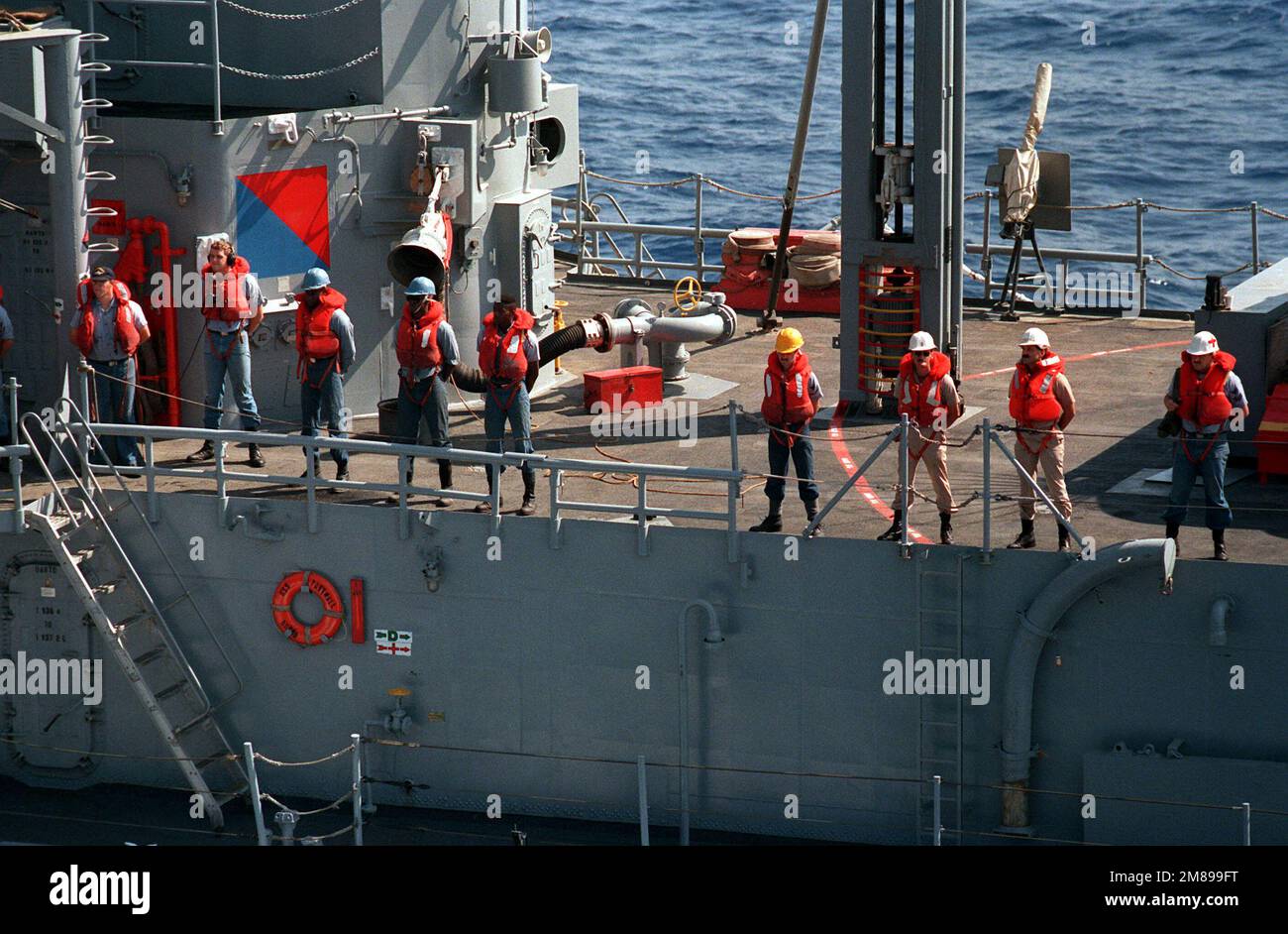 Members of the deck force underway replenishment unit stand near the ...
