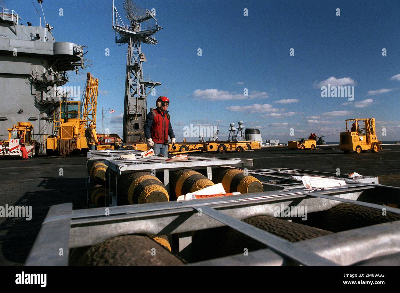 An aviation ordnanceman stands near several pallets of Mark 82 500 ...