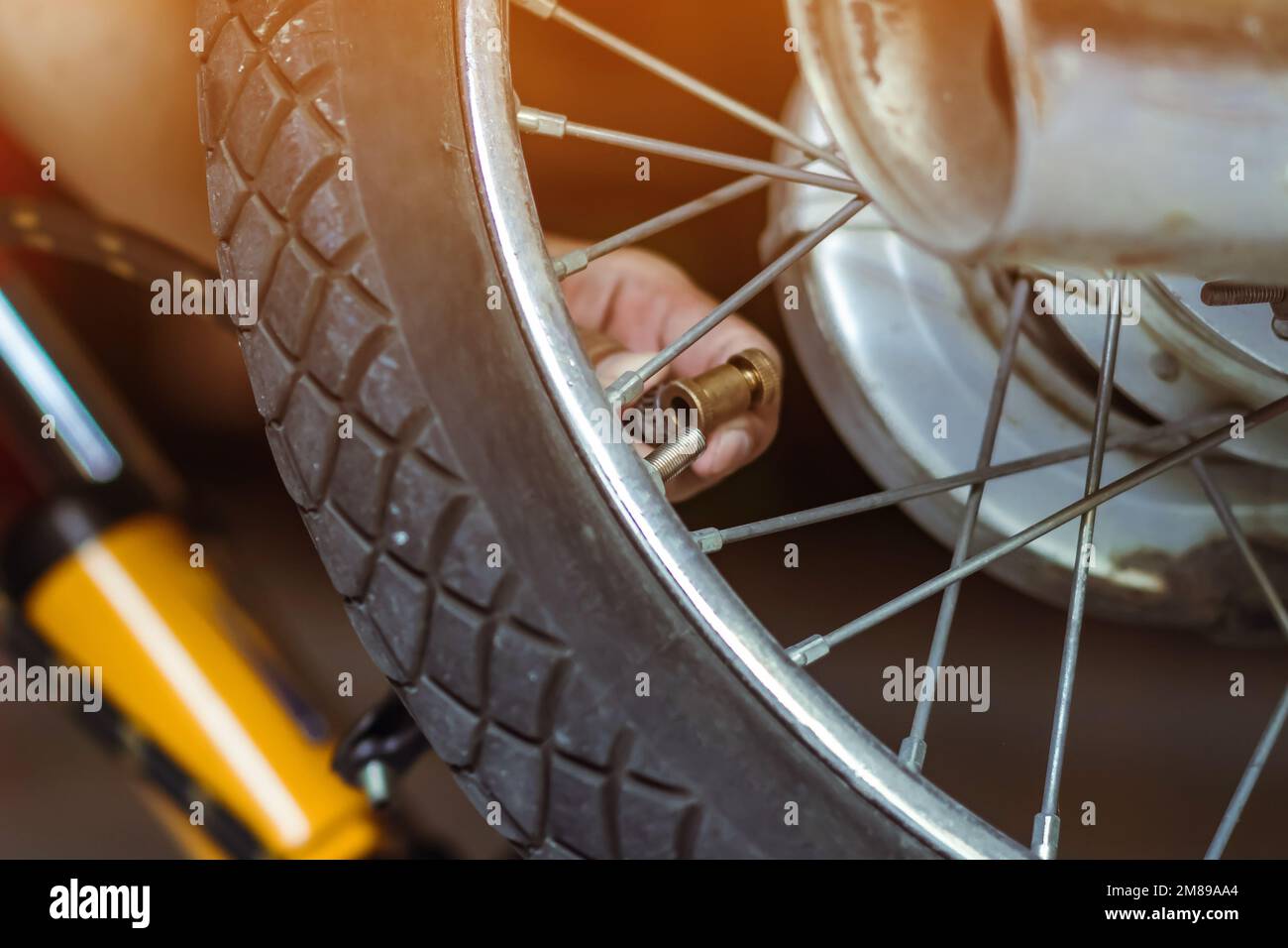 Hands of man check inflator pressure and inflates tire on motorcycle ...