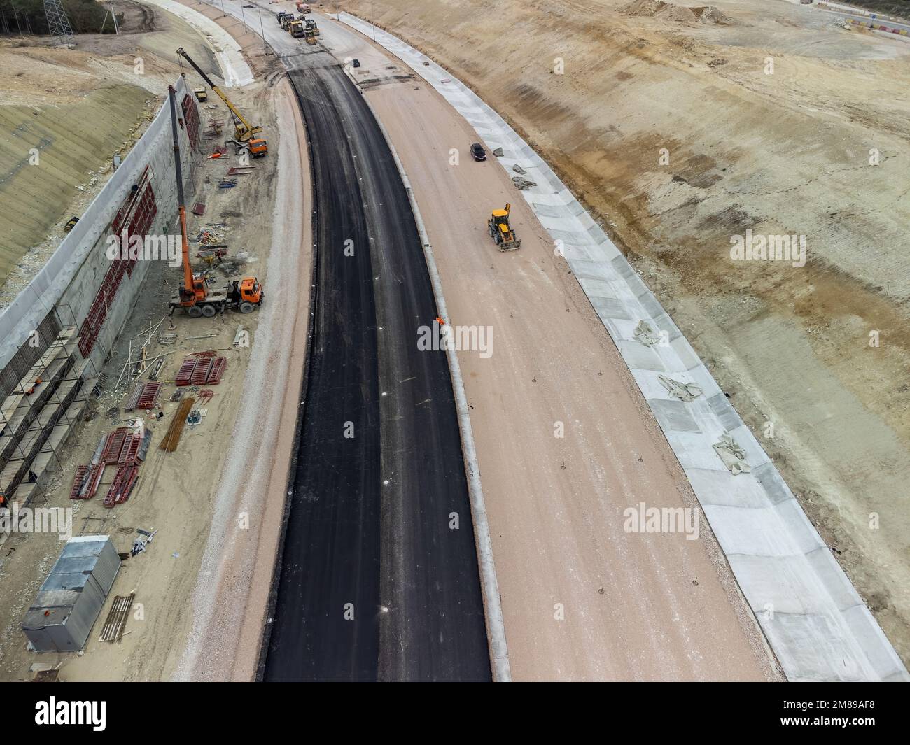 Mountain road constraction. Workers reinforce the slope over the new ...