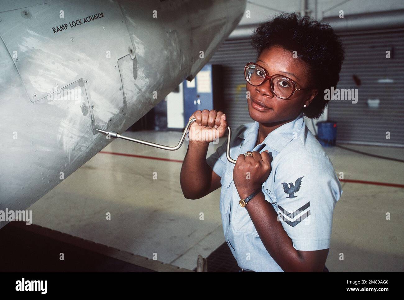 An aviation structural mechanic 2nd class removes a ramp lock actuator ...