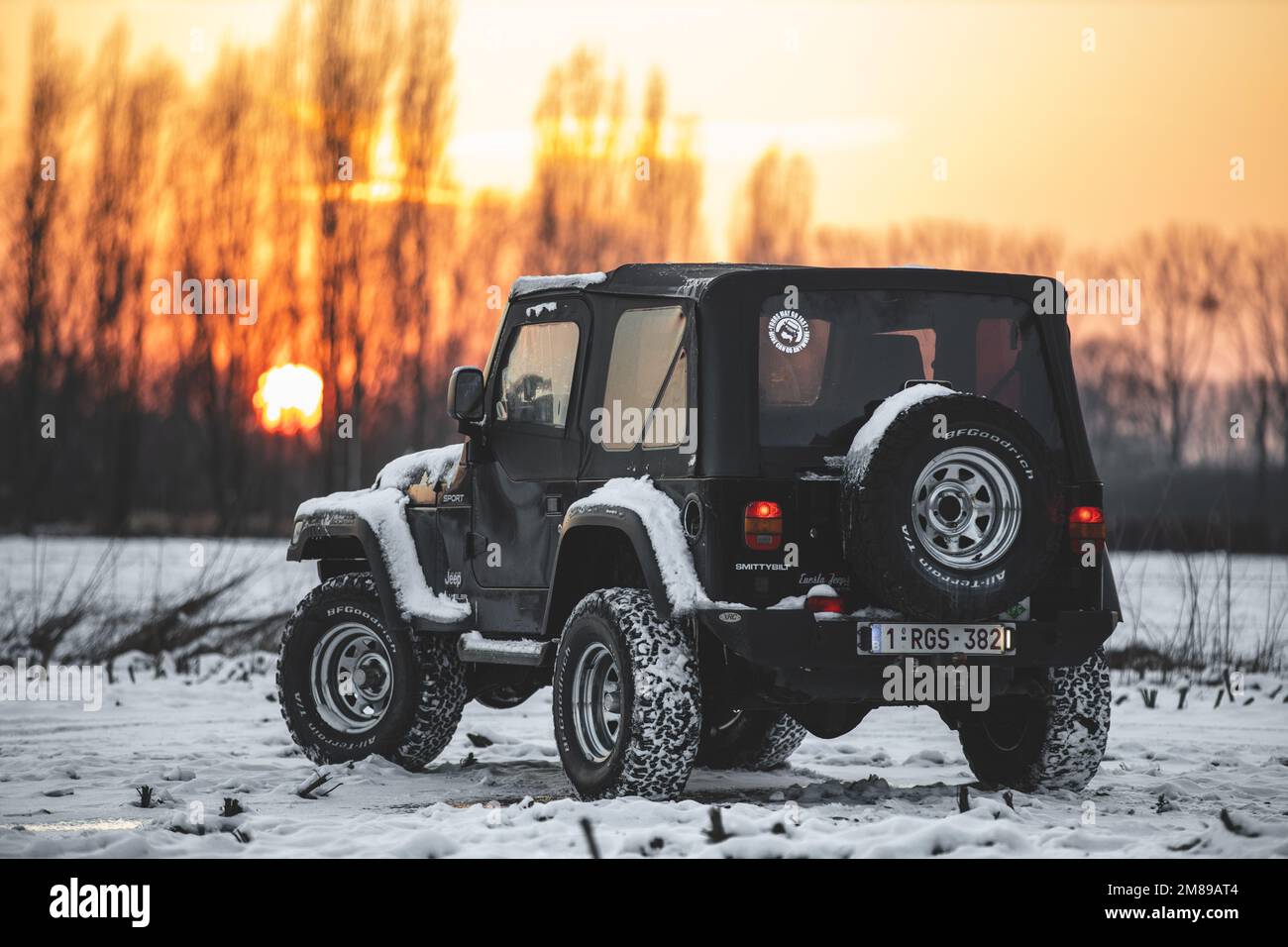 A Jeep wrangler covered in snow at sunset on a cold winter day Stock ...