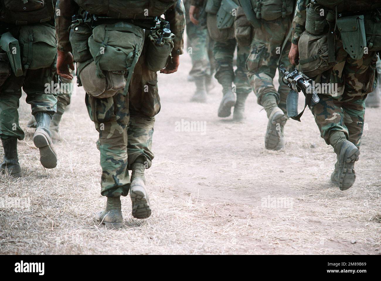 Members of the 82nd Airborne Division move out after landing during a ...