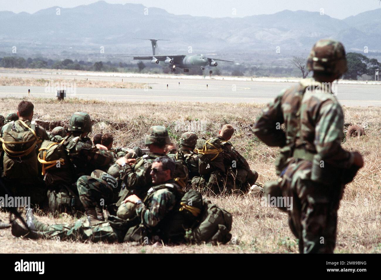 Members of the 82nd Airborne Division watch as a C-141B Starlifter ...
