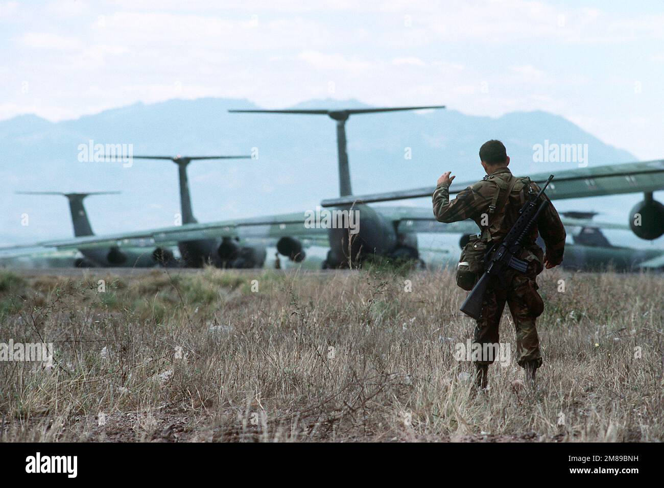 A lone member of the 82nd Airborne Division waves goodbye as C-141B ...