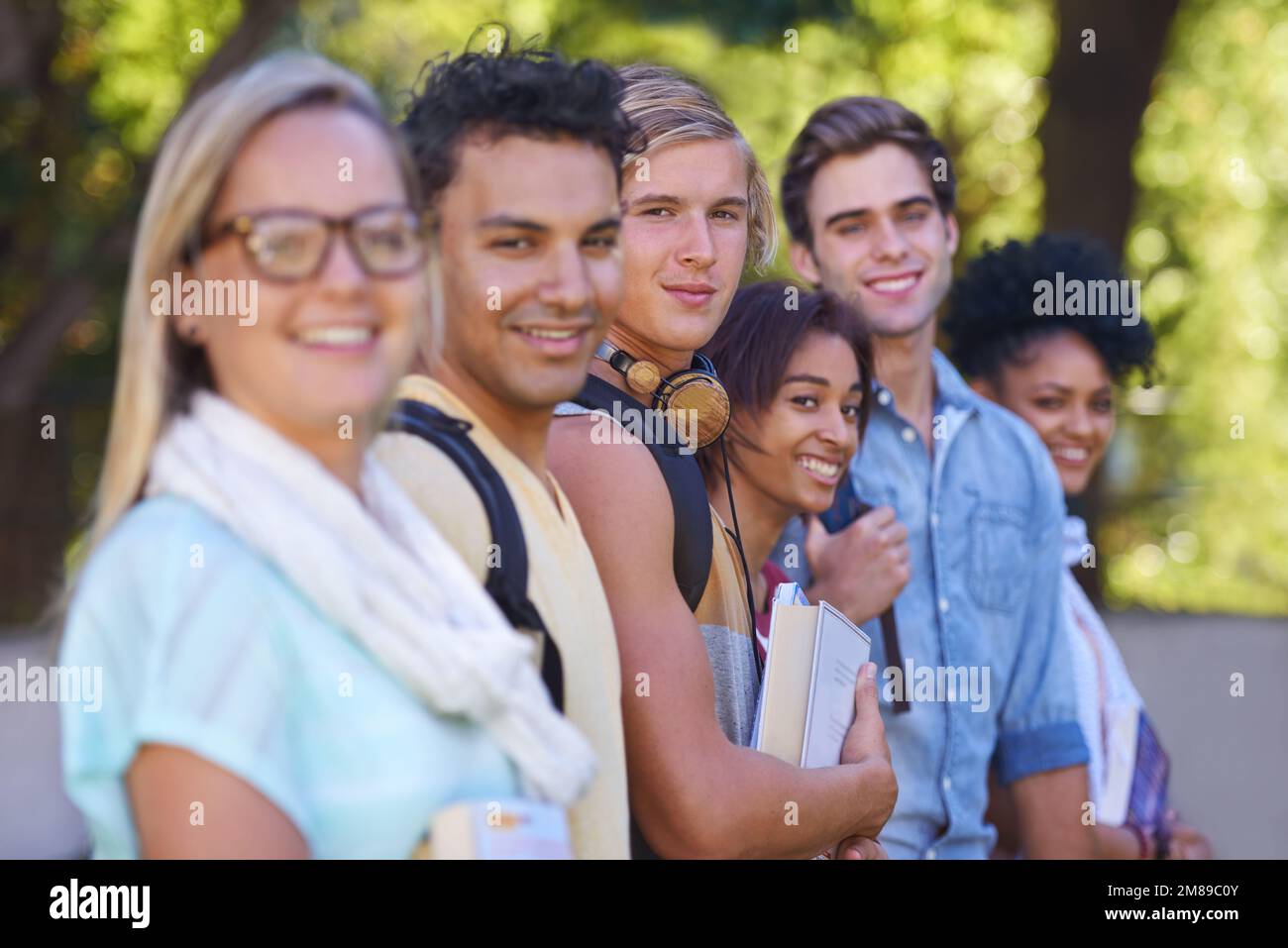 Smile for the camera. Portrait of a group of smiling university students standing outside Stock ...