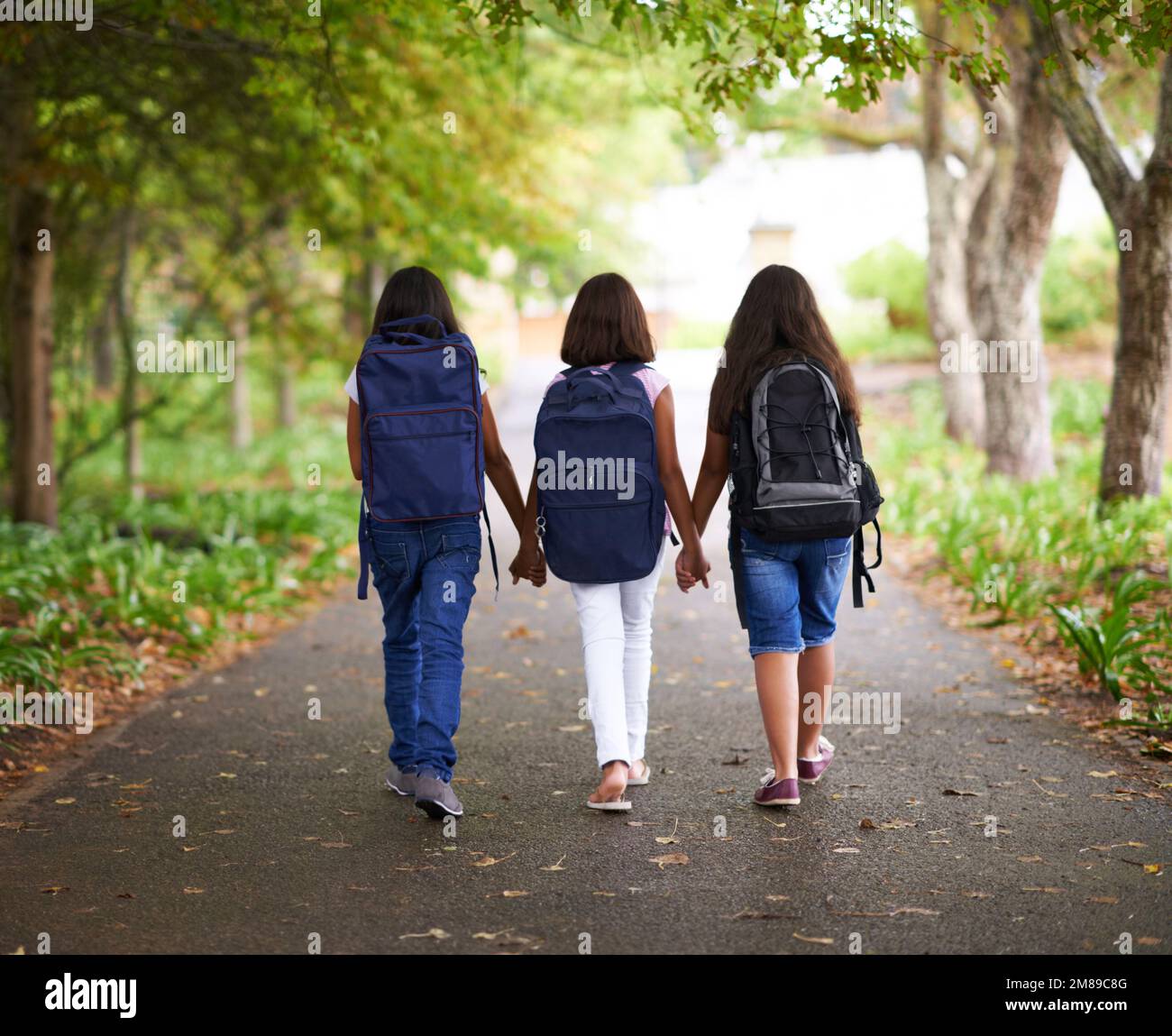 Friends forever. Three young female classmates walking outside Stock ...