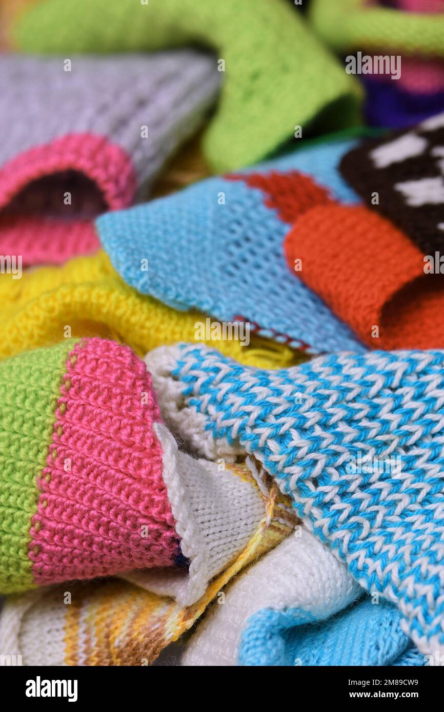 A montage pile of colourful, handmade, knitted woollen items in soft ...