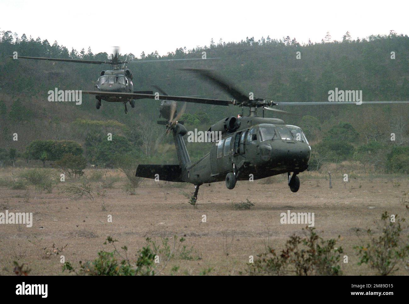 Three troop-carrying UH-60 Black Hawk (Blackhawk) helicopters fly into ...