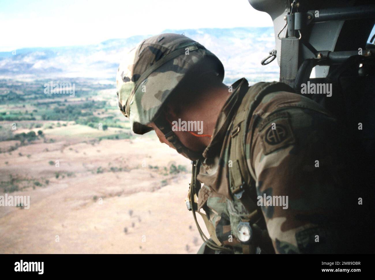 An 82nd Airborne Division soldier looks out of the open door of a ...