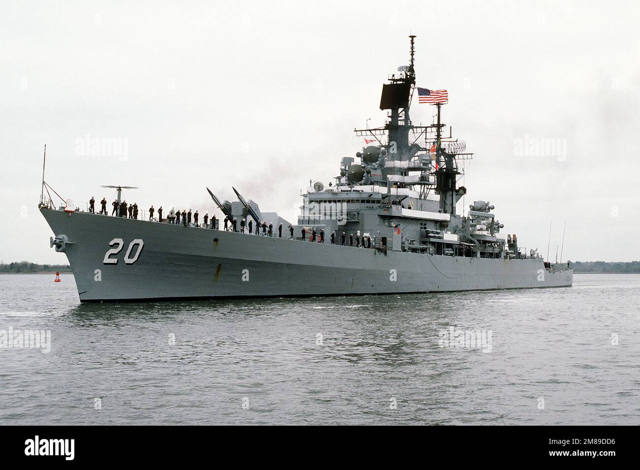 Crew members man the rails aboard the guided missile cruiser USS ...