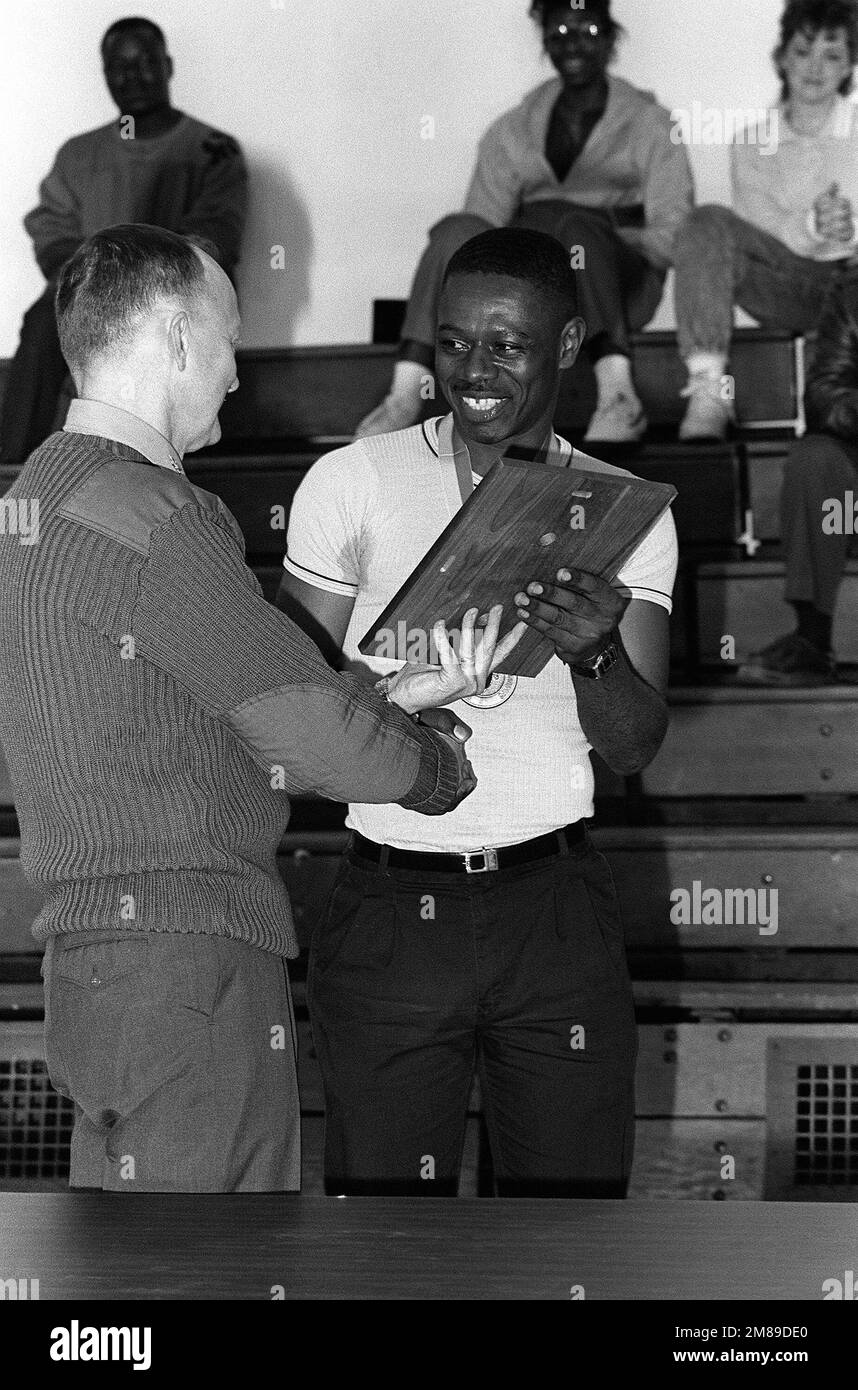 The coach of the women Marine's basketball team accepts an award after ...