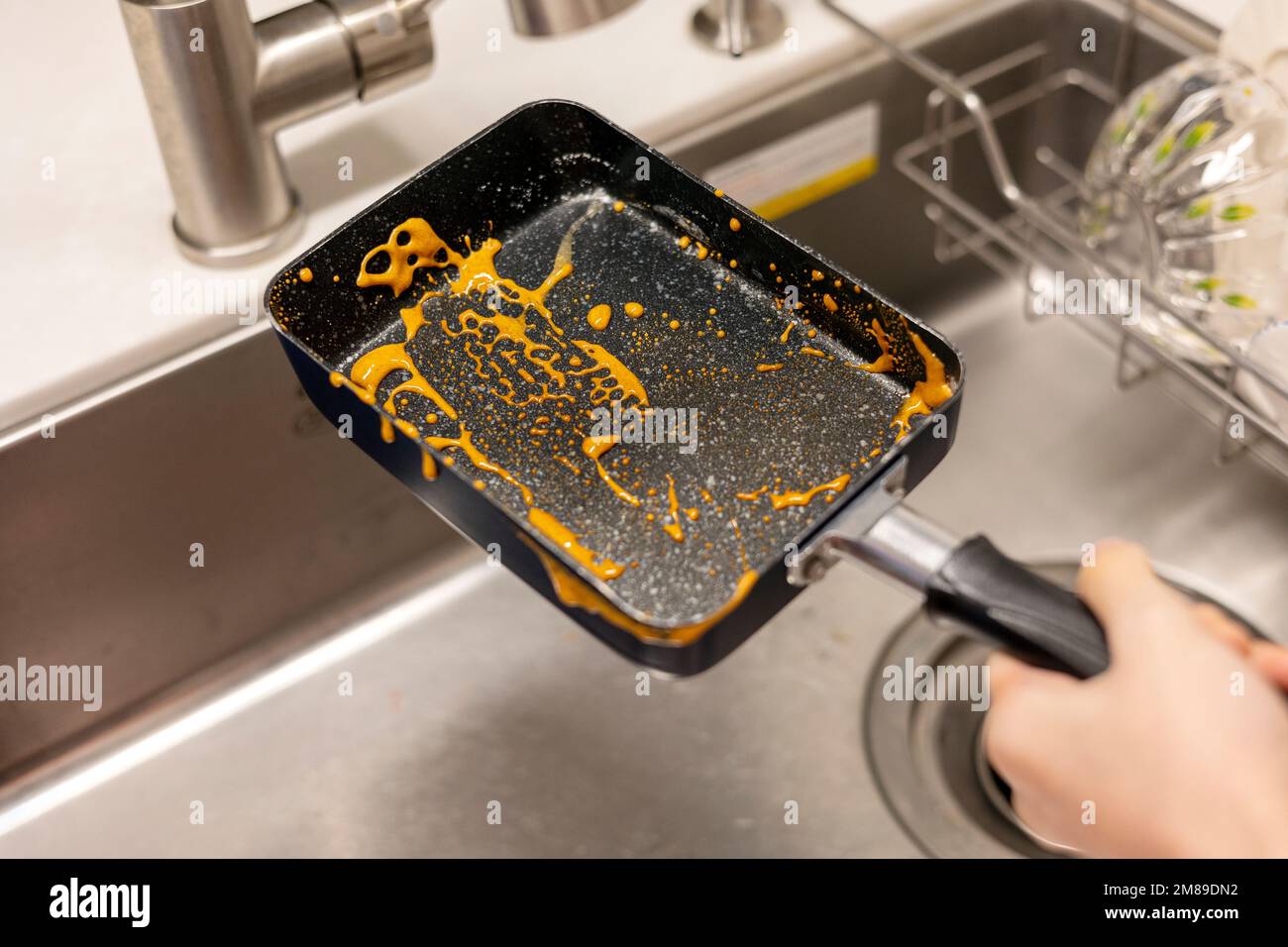 The dirty frying pan is being washed in the kitchen sink Stock Photo ...