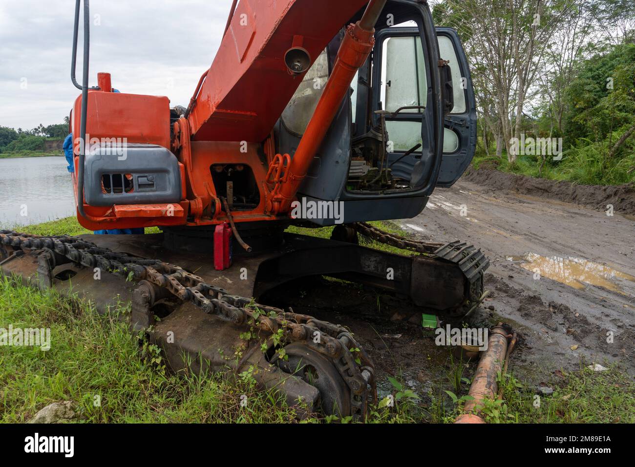 Broken excavator abandoned in the middle of plantation nature landscape ...