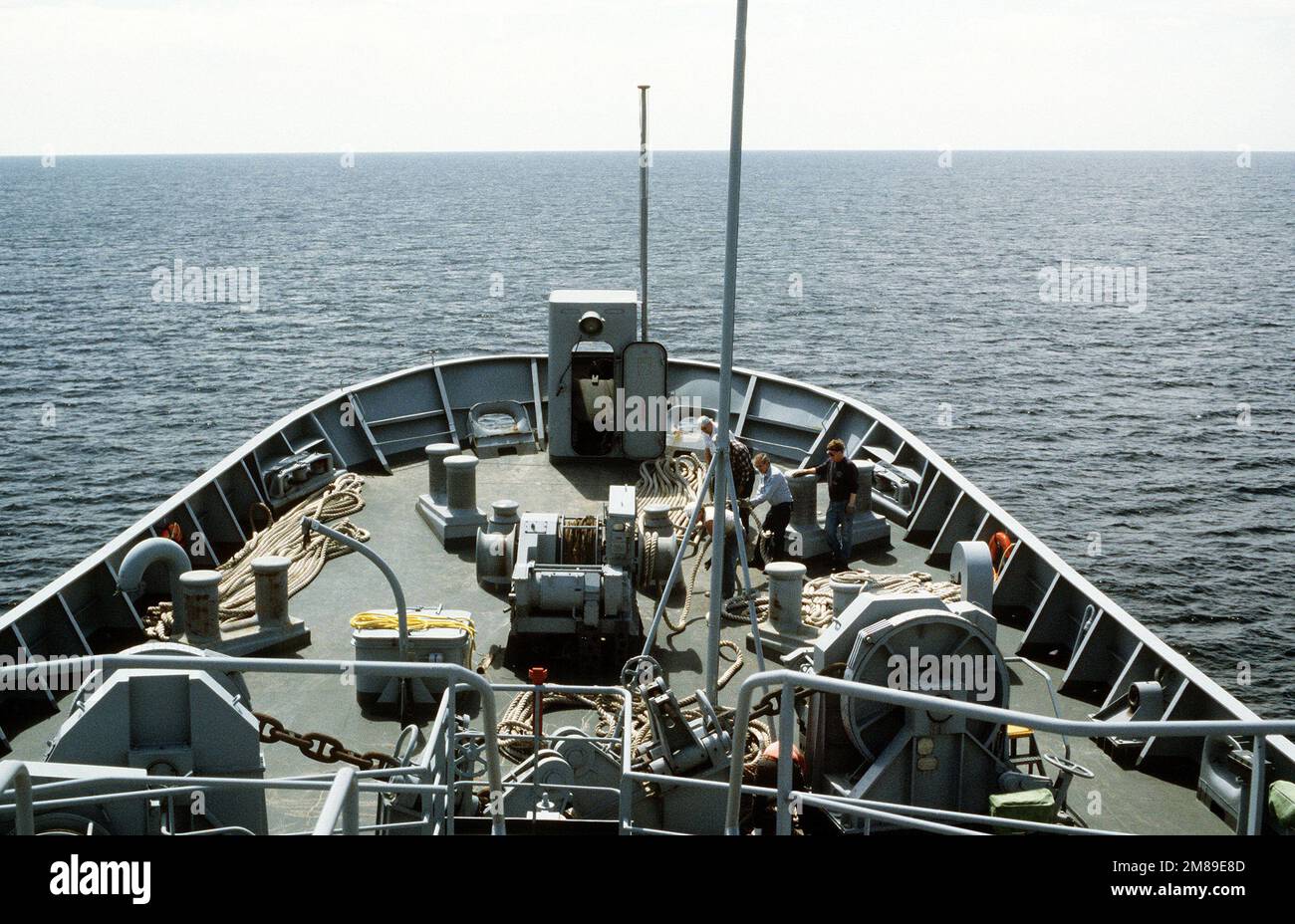 Crewmen work with mooring lines on the bow of the aviation logistic ...
