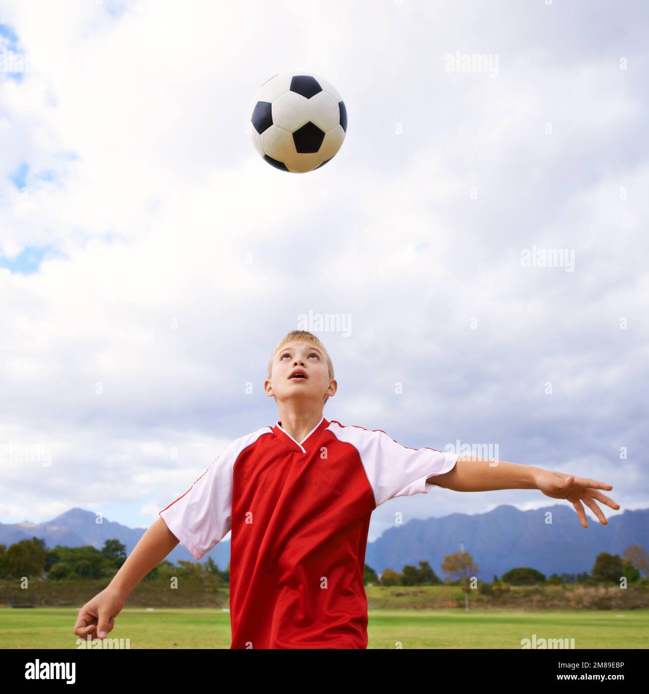 Hes always early to practice. a young boy playing with a soccer ball ...