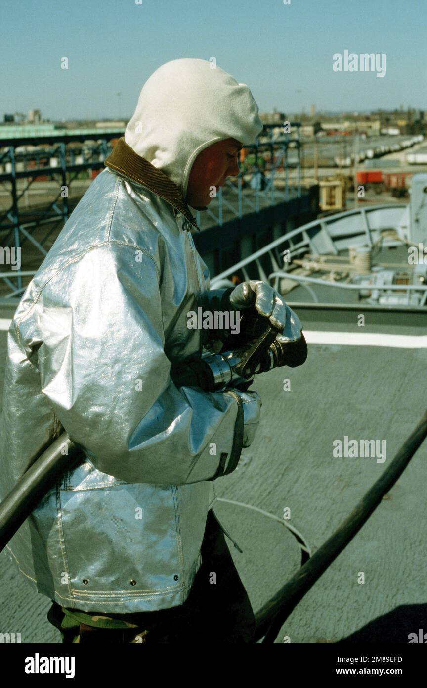 A Marine familiarizes himself with some of the firefighting equipment ...