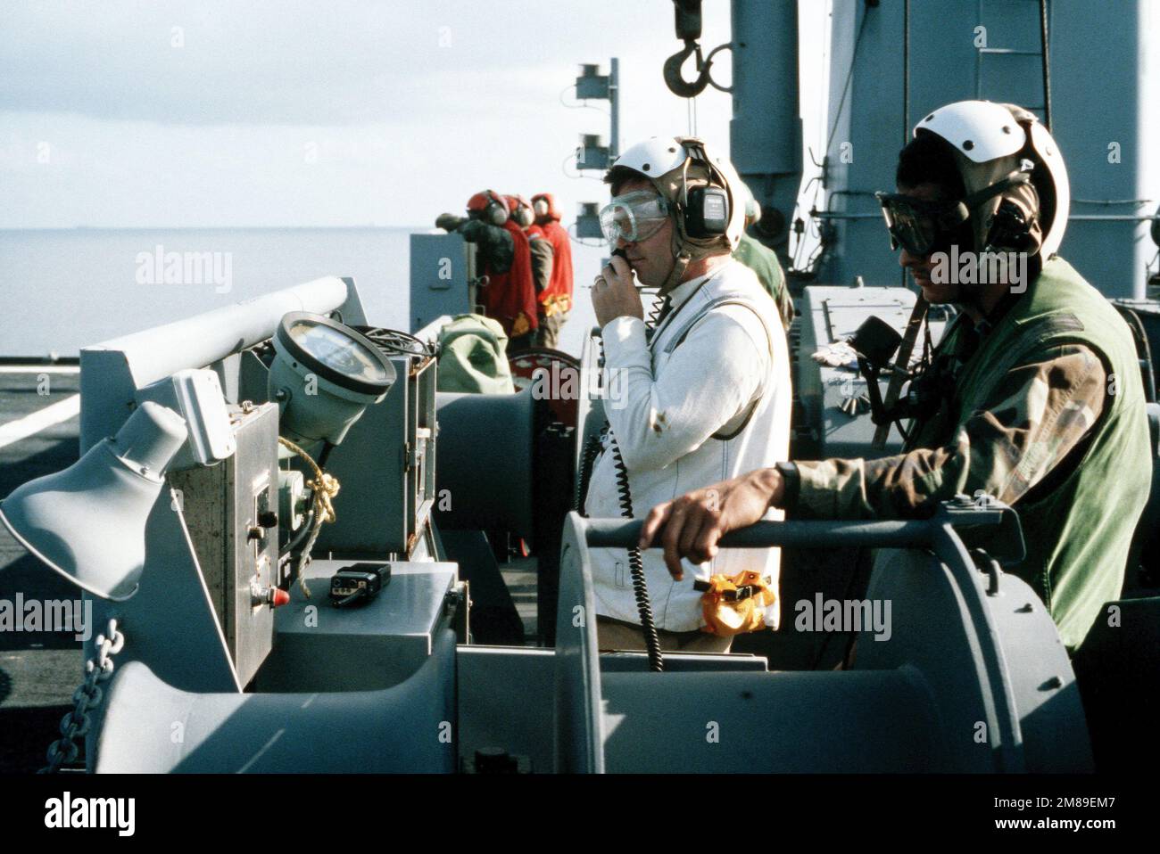 Flight deck crew members monitor flight operations aboard the aviation ...