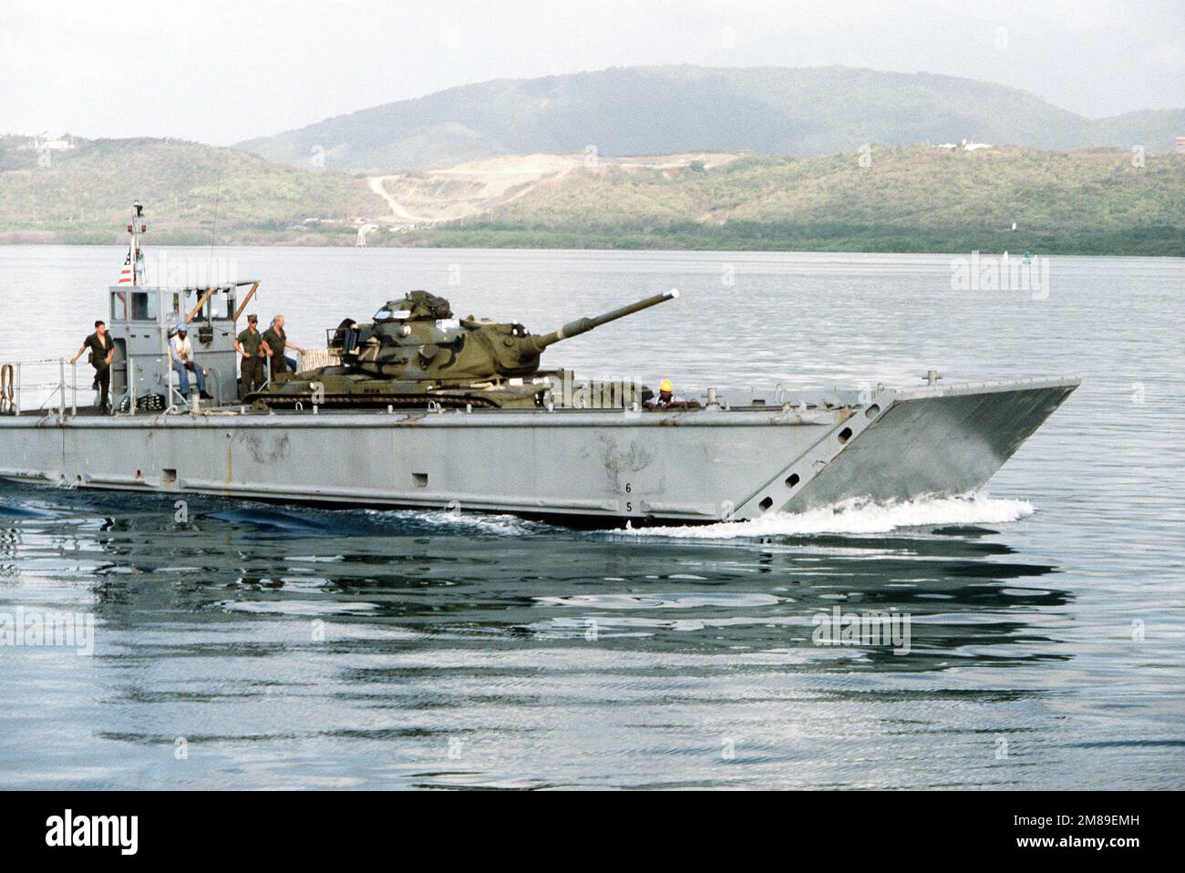 An LCM-8 Mechanized landing craft Transports an M-60A1 tank toward ...