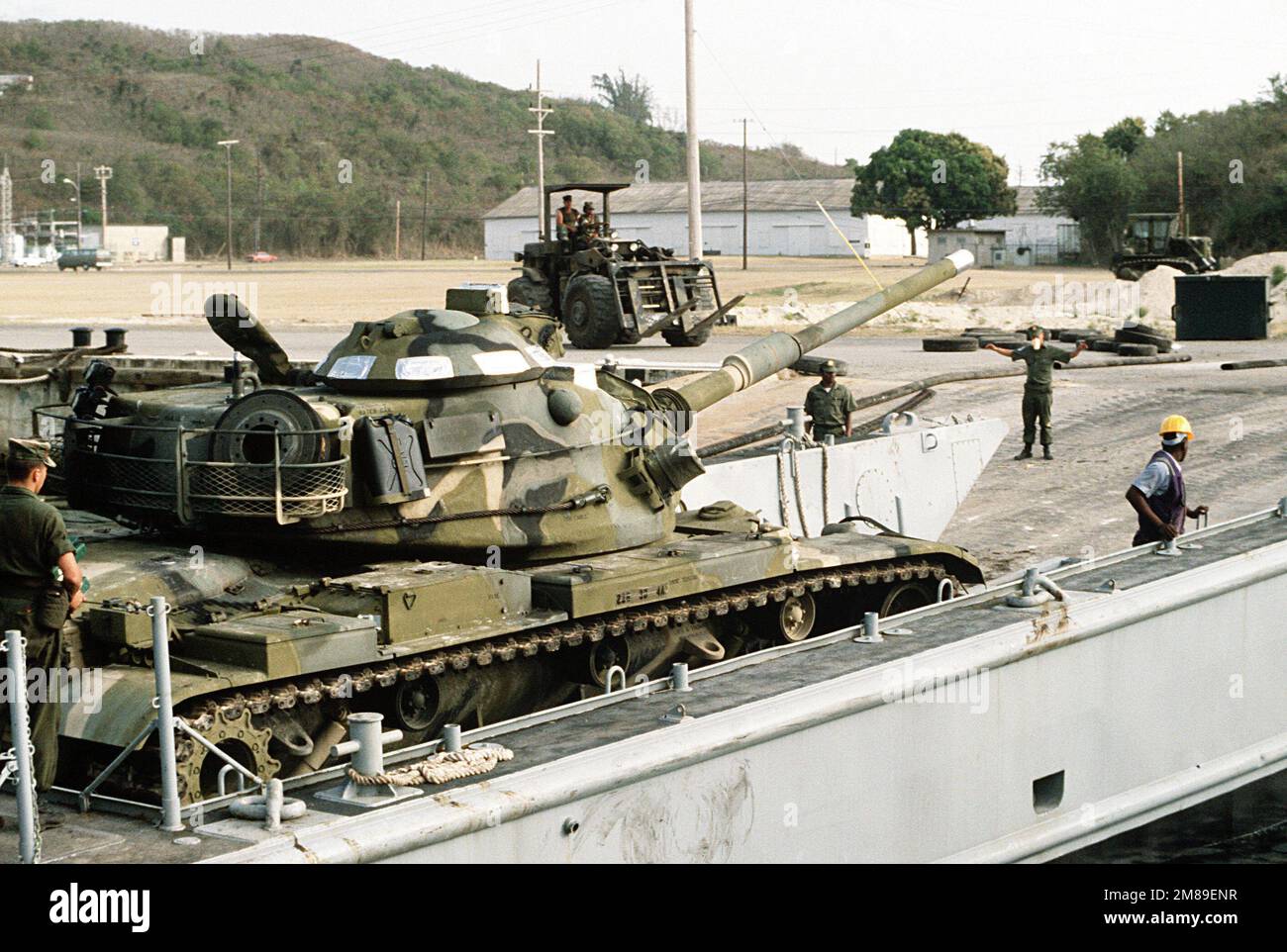 An M-60A1 tank is driven off an LCM-8 mechanized landing craft during ...