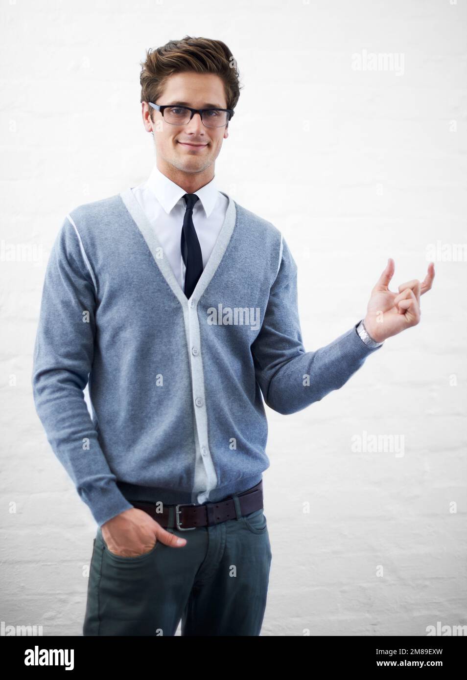 Your product fits between his fingers. A handsome young nerdy guy holding an imaginary product ...