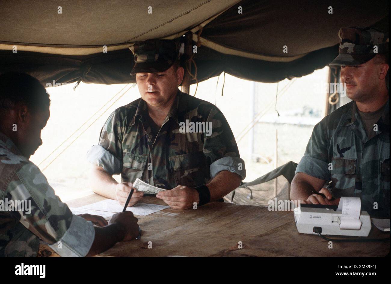 A Marine signs for his pay in the disbursing tent during exercise Ocean ...
