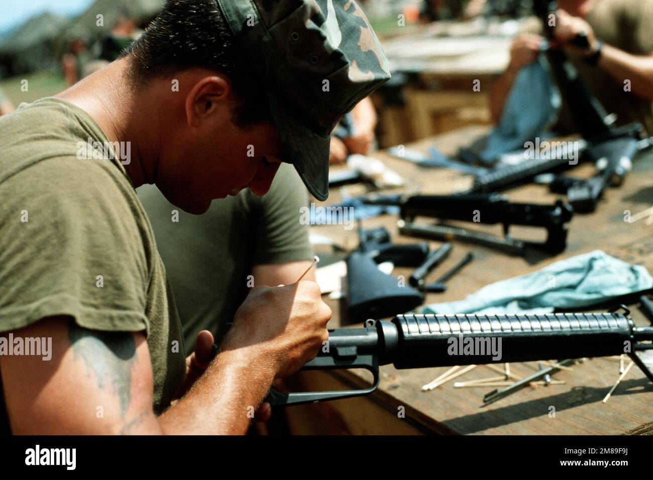 A Marine cleans the upper receiver of his M-16A2 rifle during exercise ...