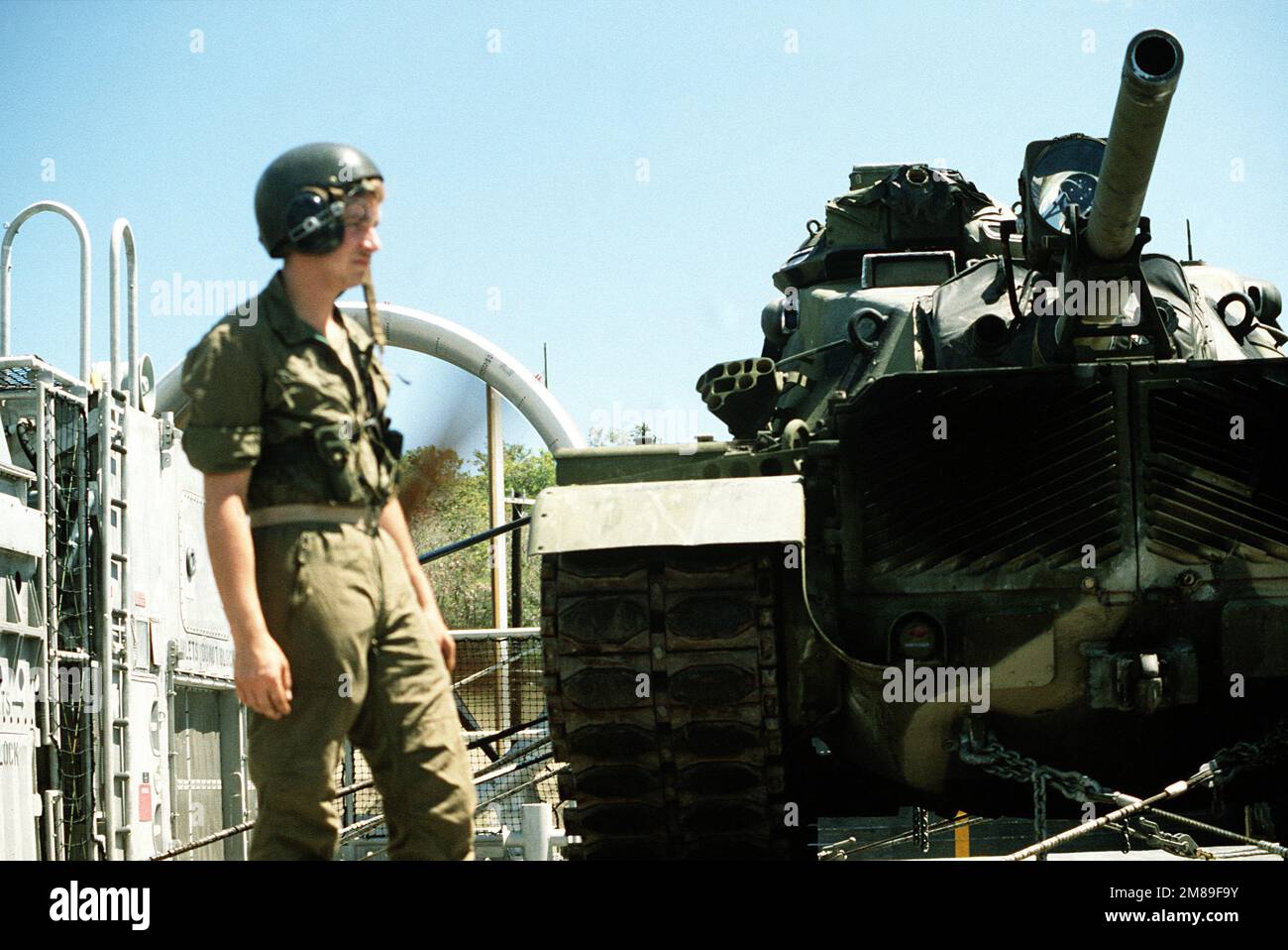 A Marine tank crewman stands beside his M-60A1 tank on the deck of an ...