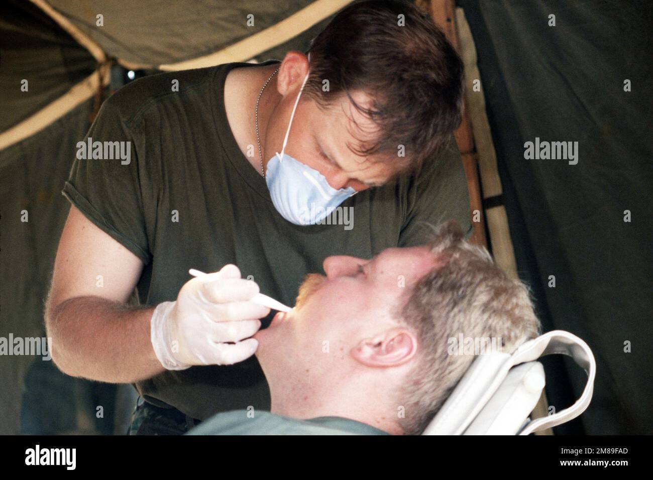 A Navy dentist works on a sailor's teeth during exercise Ocean Venture ...