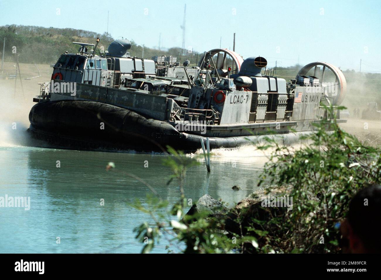The air cushion landing craft LCAC-7 departs the beach with a load of ...